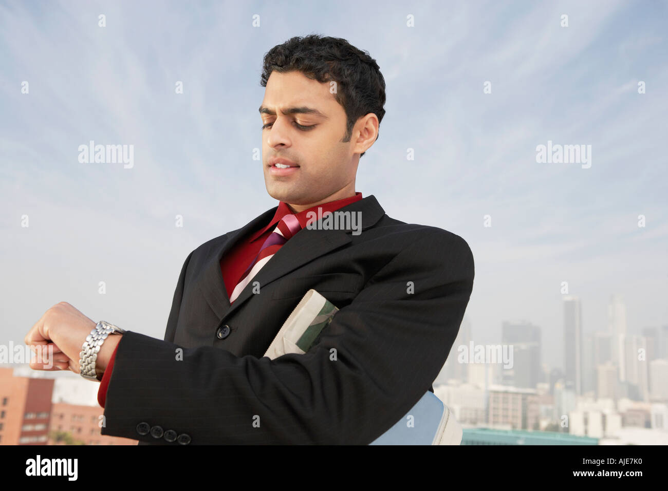 Business man checking watch on city street Stock Photo - Alamy