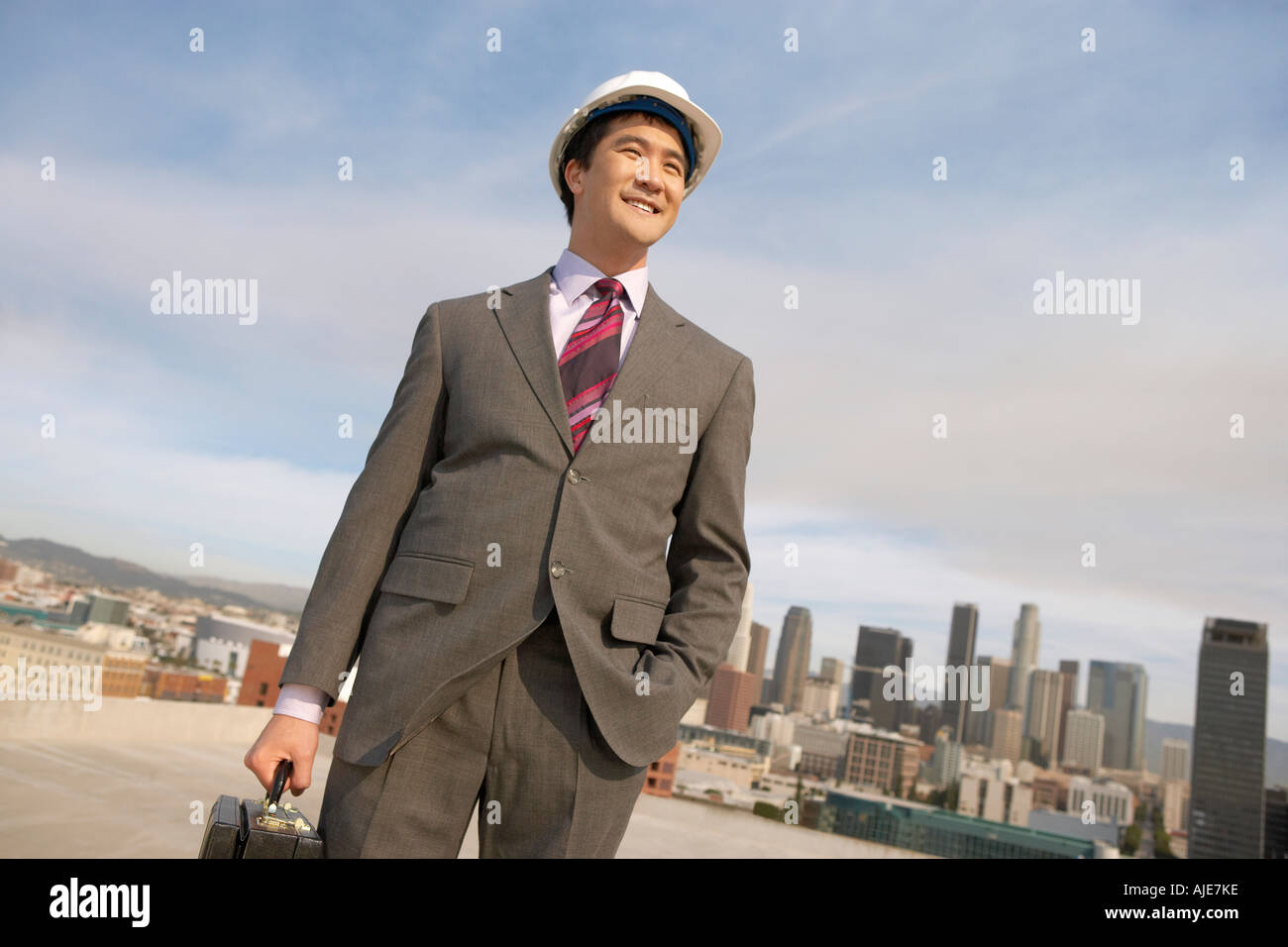 Business man wearing hard hat on city rooftop Stock Photo - Alamy
