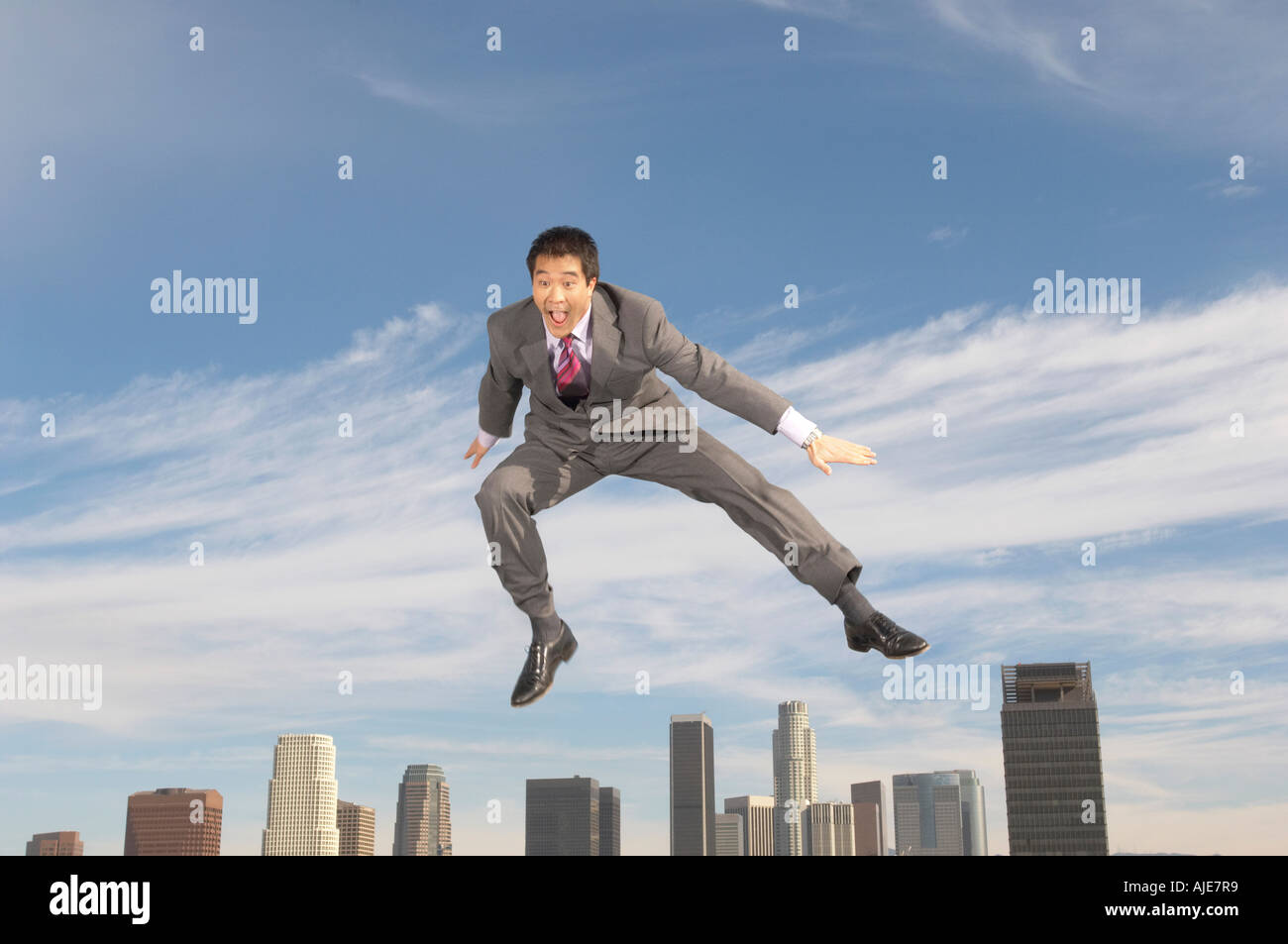 Business man jumping mid-air above city Stock Photo - Alamy