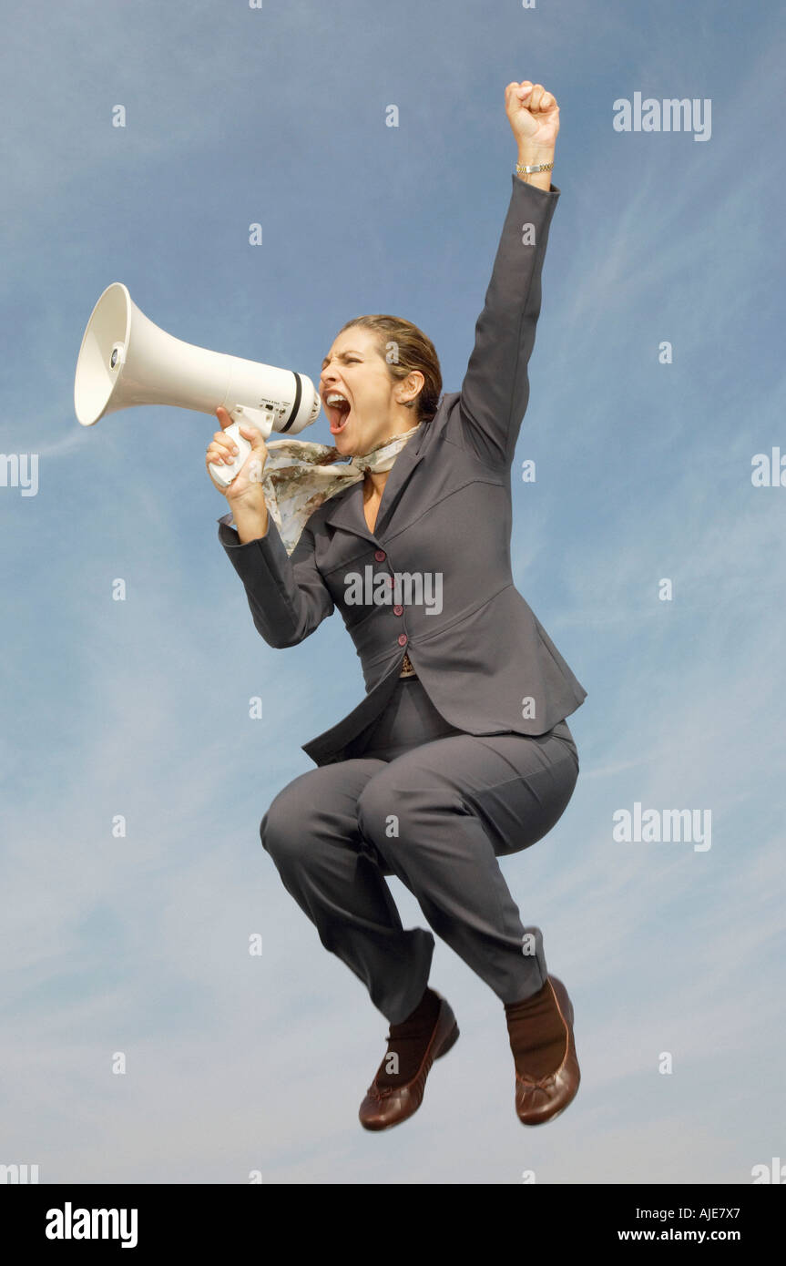 Business woman shouting in bullhorn mid-air outdoors Stock Photo - Alamy