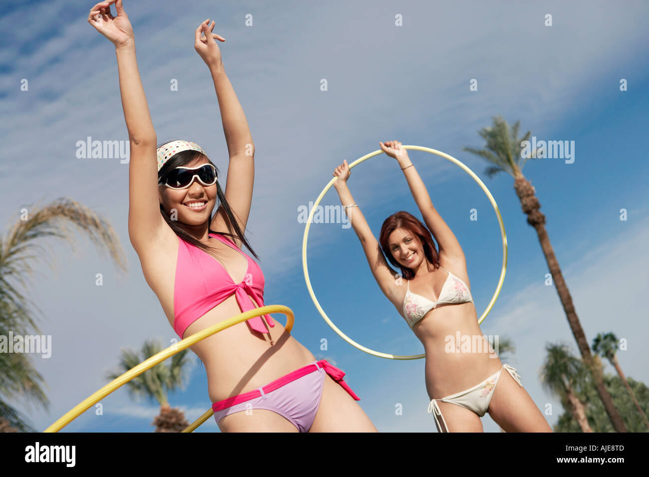 Young women in bikinis with hoops Stock Photo - Alamy
