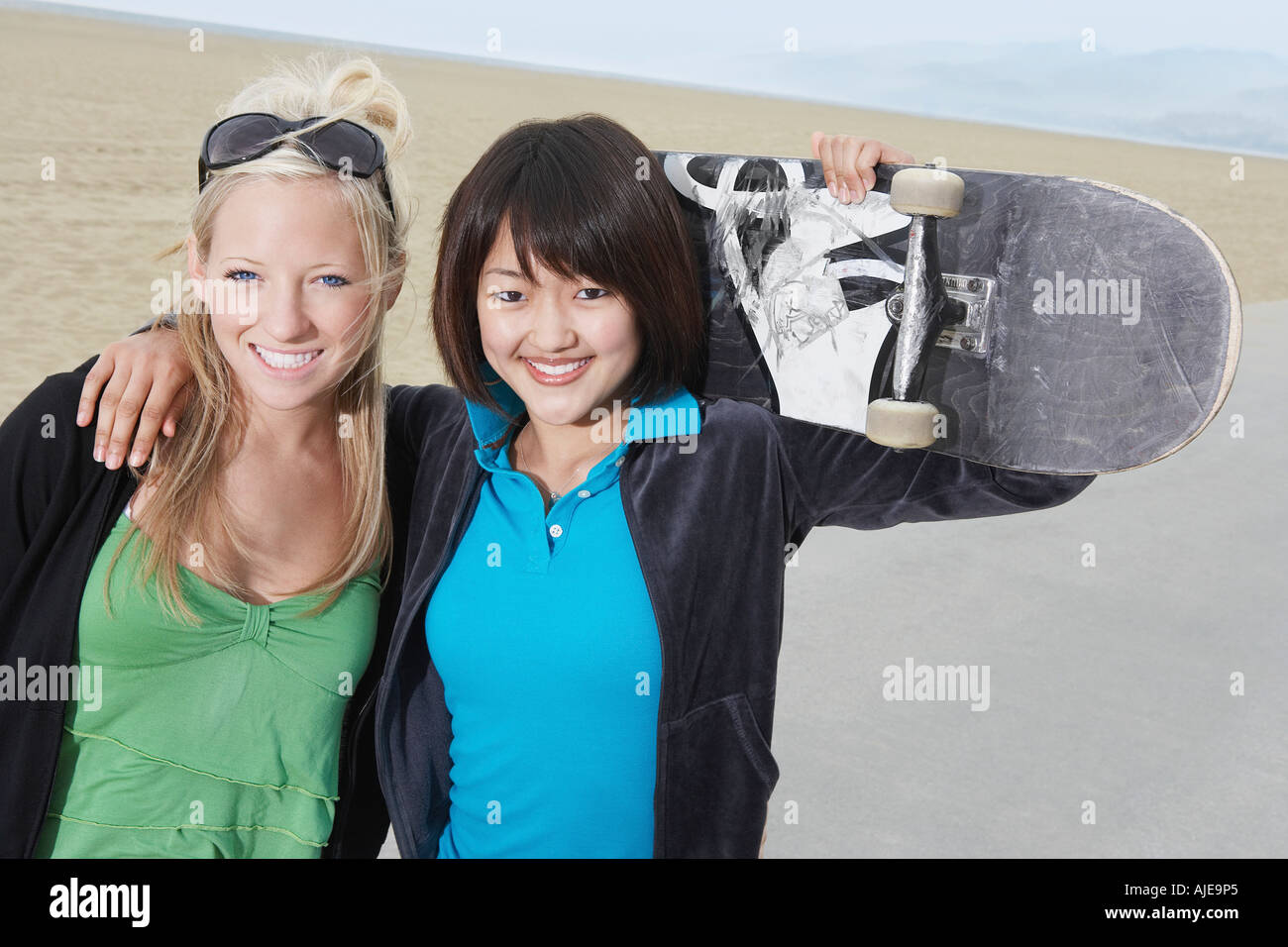 Two young female skateboarders on beach, portrait Stock Photo - Alamy