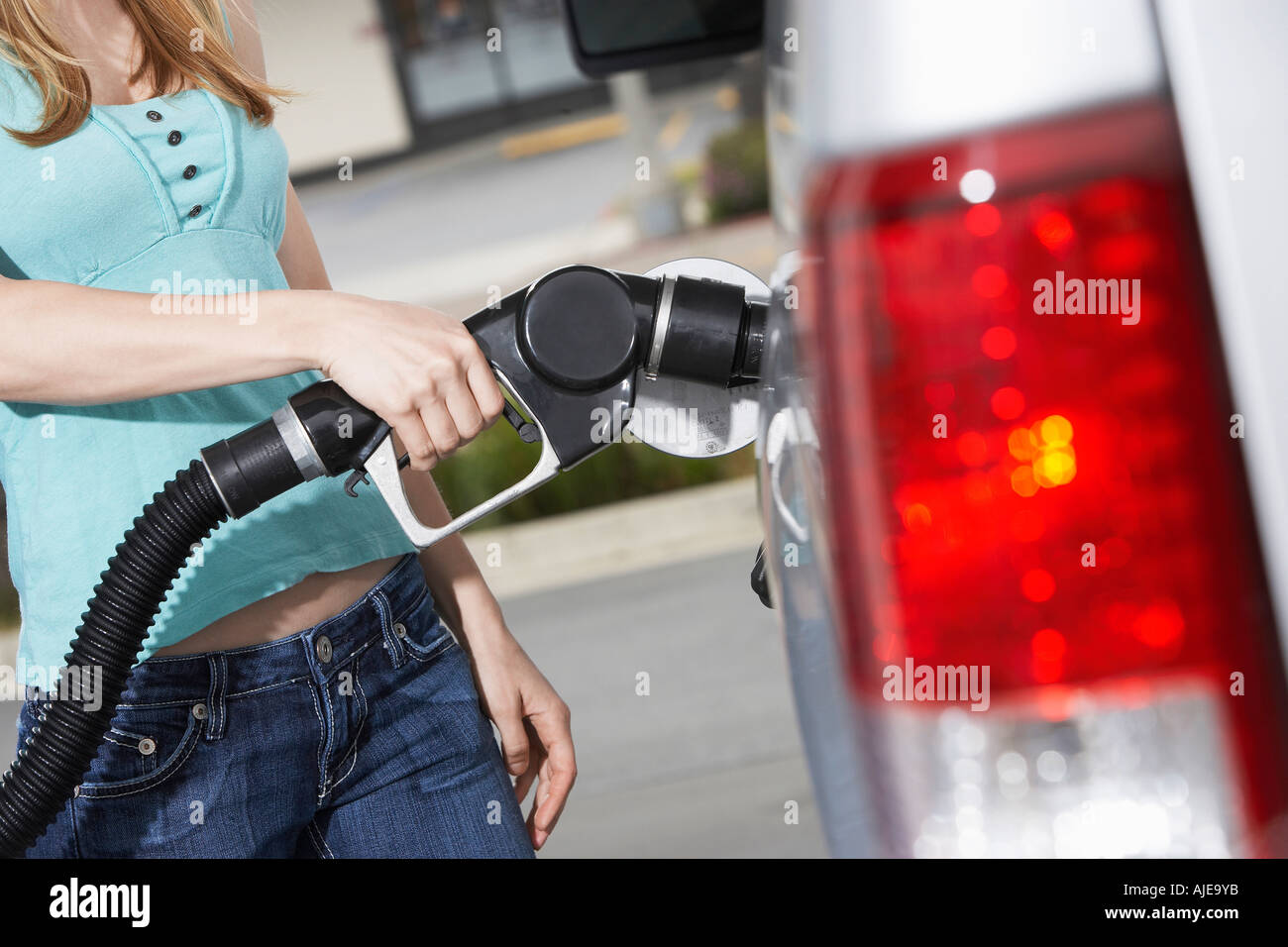 Young woman filling car with gas at gas station, mid section Stock ...