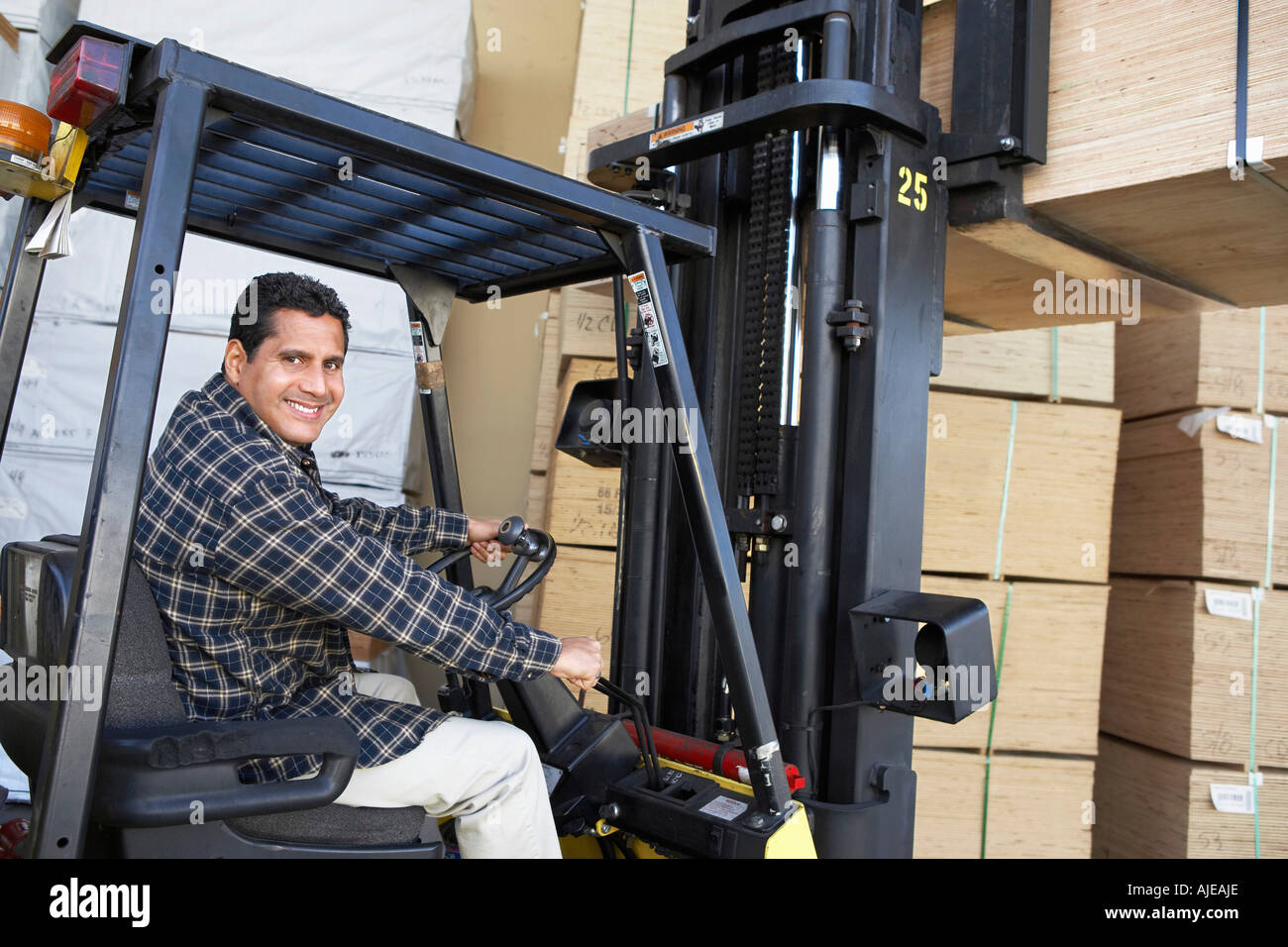 Man using forklift to lift stack of wood Stock Photo - Alamy