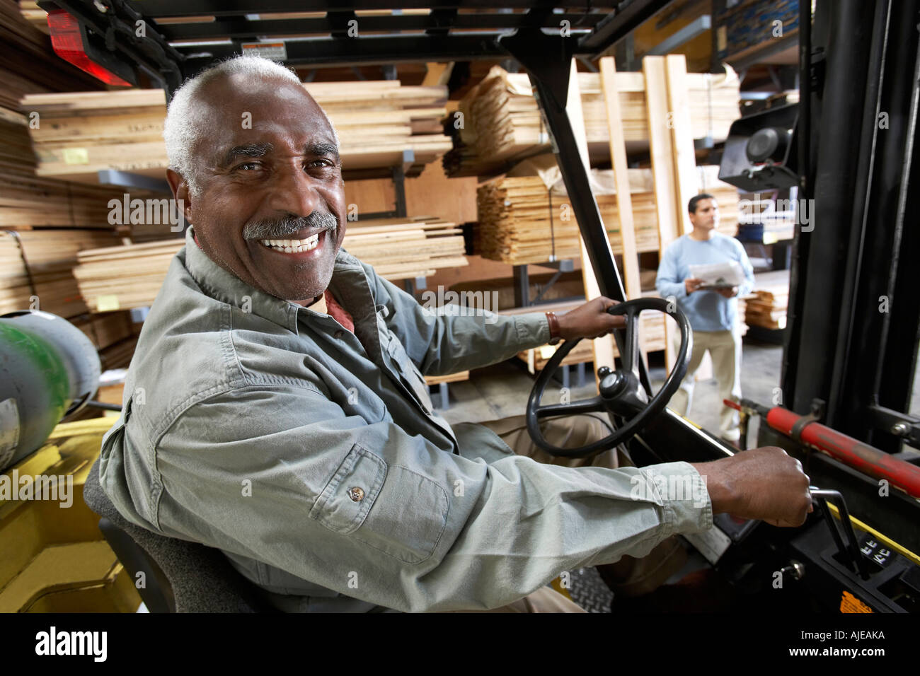 Forklift Driver on forklift in Lumber Warehouse Stock Photo - Alamy