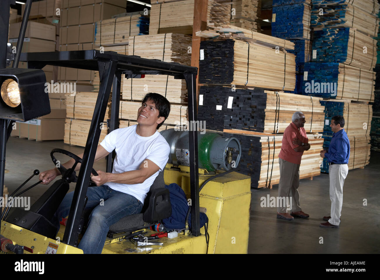 Man driving forklift in warehouse of wood Stock Photo - Alamy