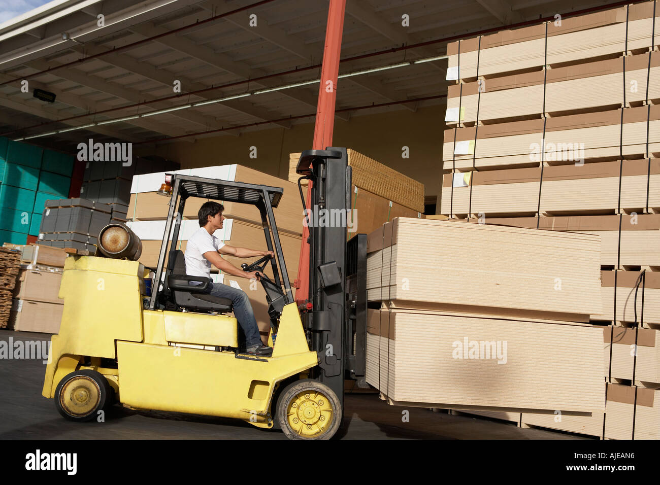 Side view of male worker operating forklift vehicle Stock Photo - Alamy