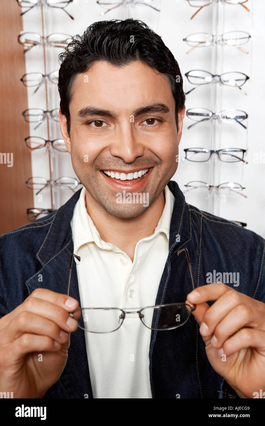Man trying on glasses at opticians Stock Photo - Alamy