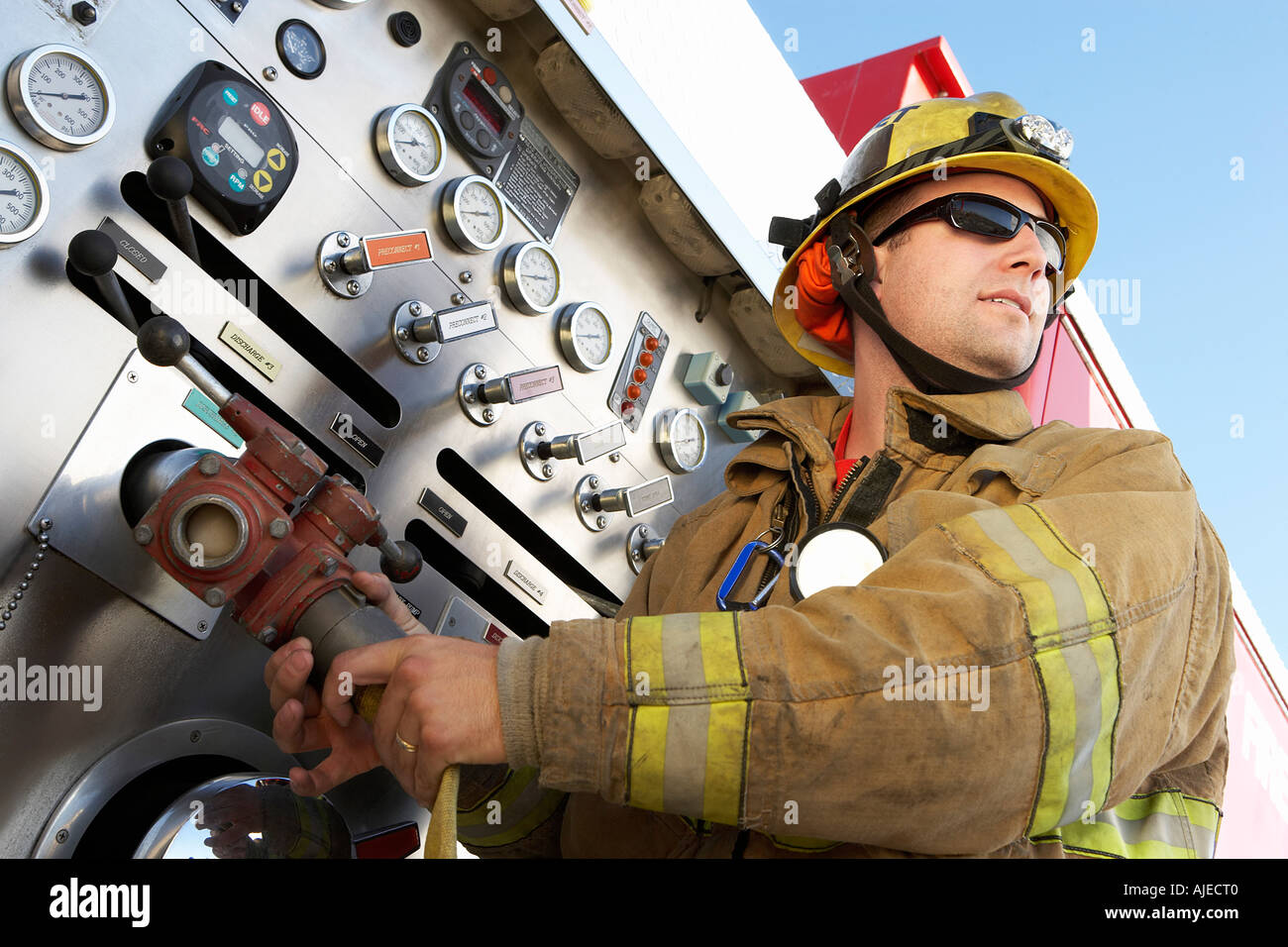 Fire fighter connecting hose to fire truck instrument panel Stock Photo ...