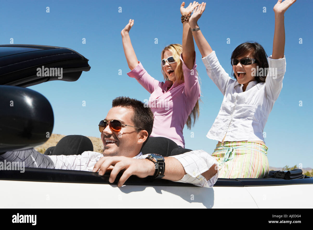 Three friends driving in convertible car Stock Photo - Alamy