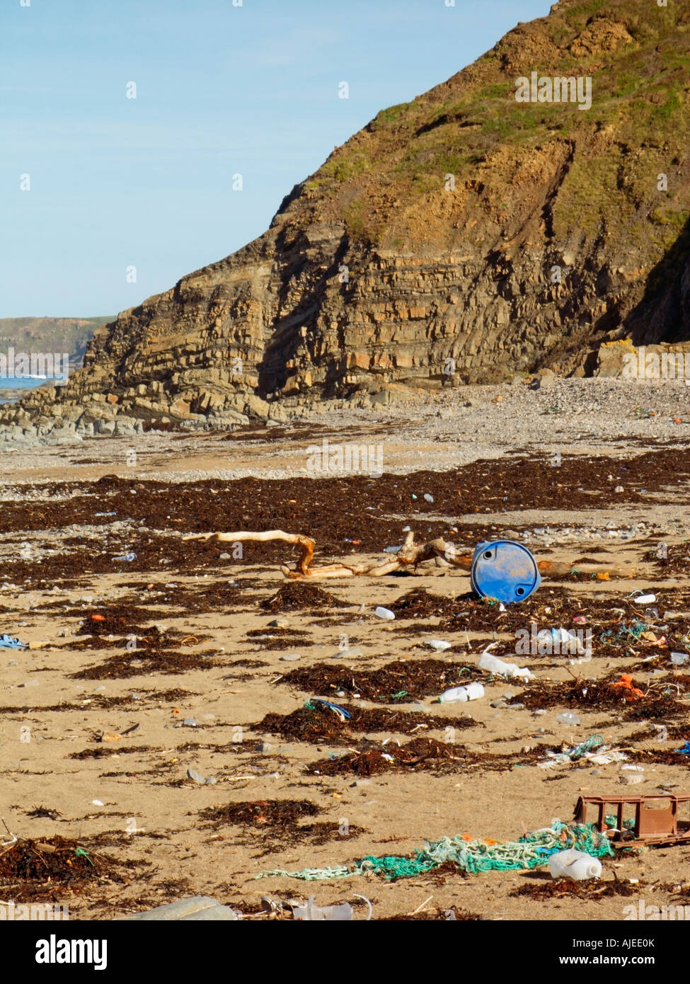 Plastic, debris and seaweed, creating a beach strandline washed-up by ...