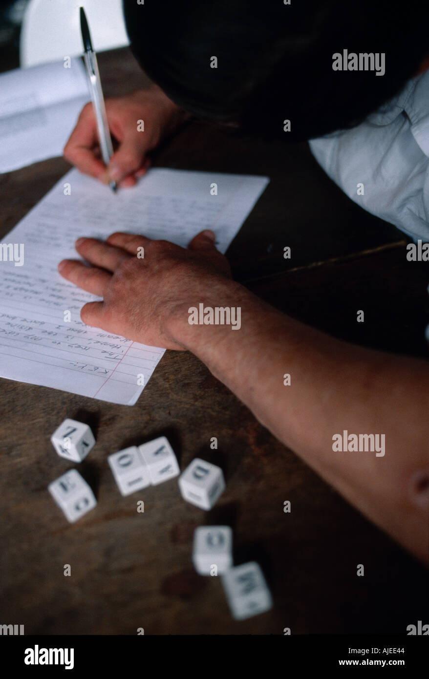 Person writing and using letter cubes to help the creative process ...