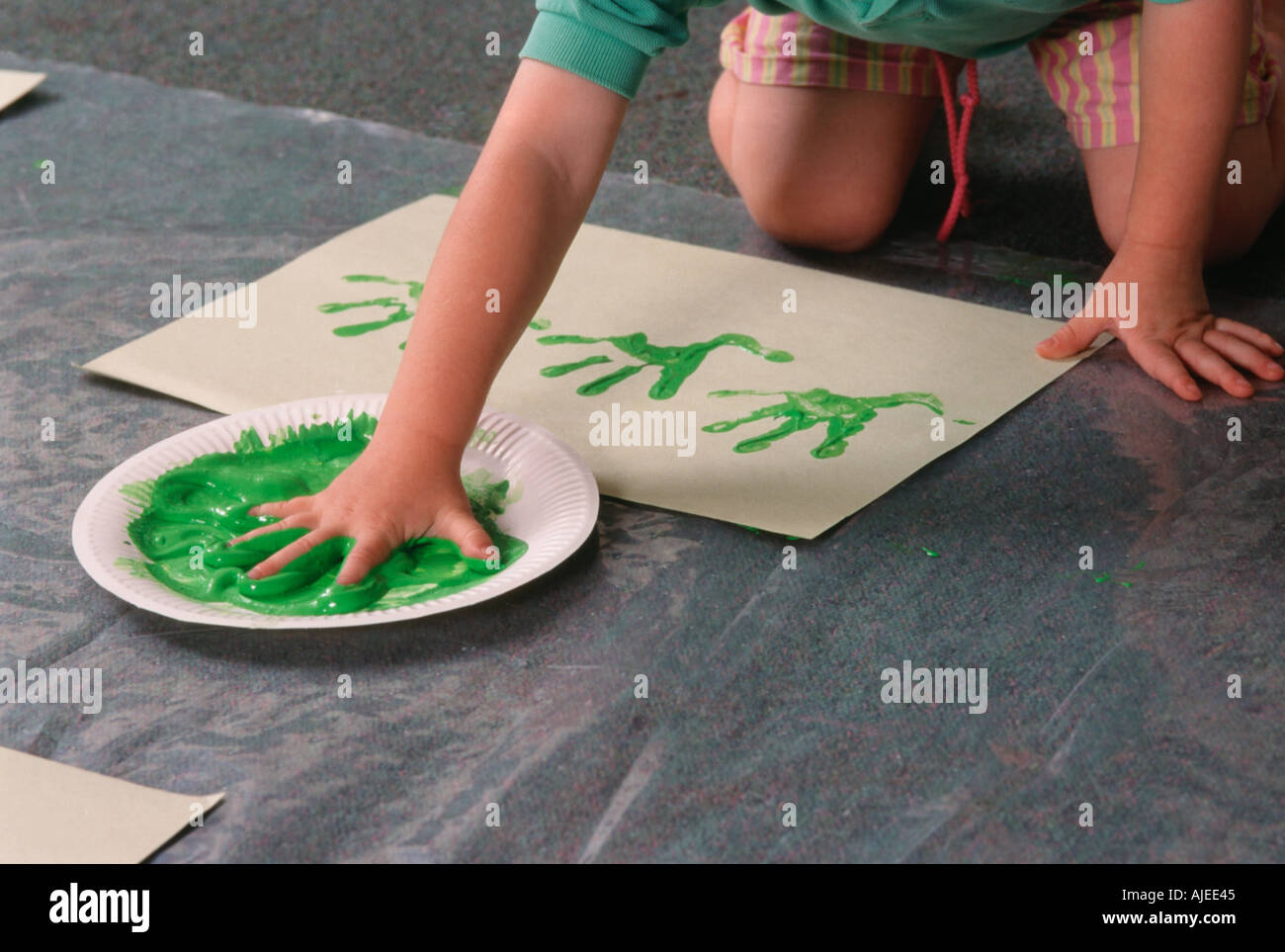 Child finger painting making a print of her hand in paint Stock Photo ...