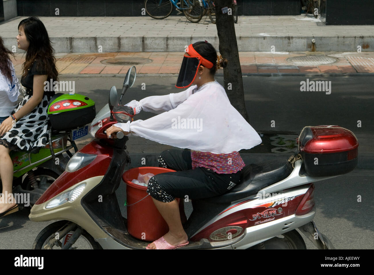 Chinese woman protecting herself from strong summer sun with a visor ...