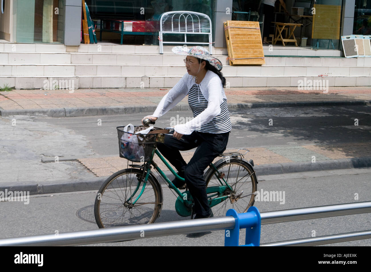 Chinese woman protecting herself from strong summer sun with a hat and ...