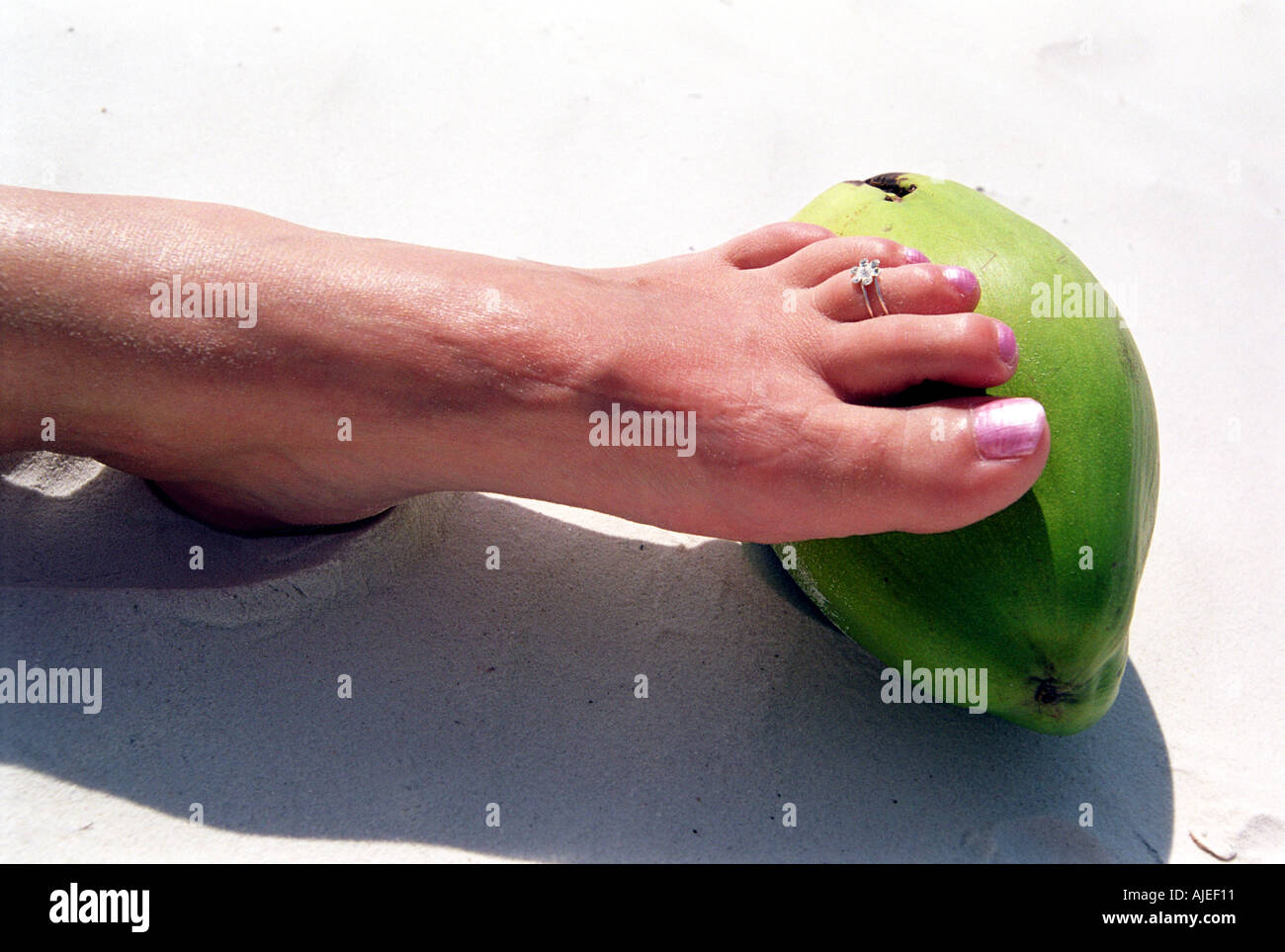 A womans foot on a coconut on a beach in Mombasa Kenya East Africa ...