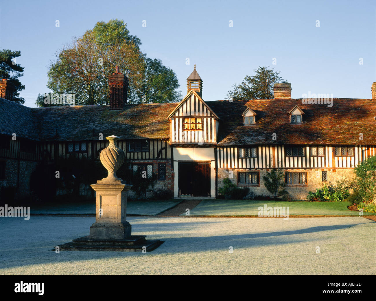 View of the Elizabethan half timbered cottages with gardens and urn at ...
