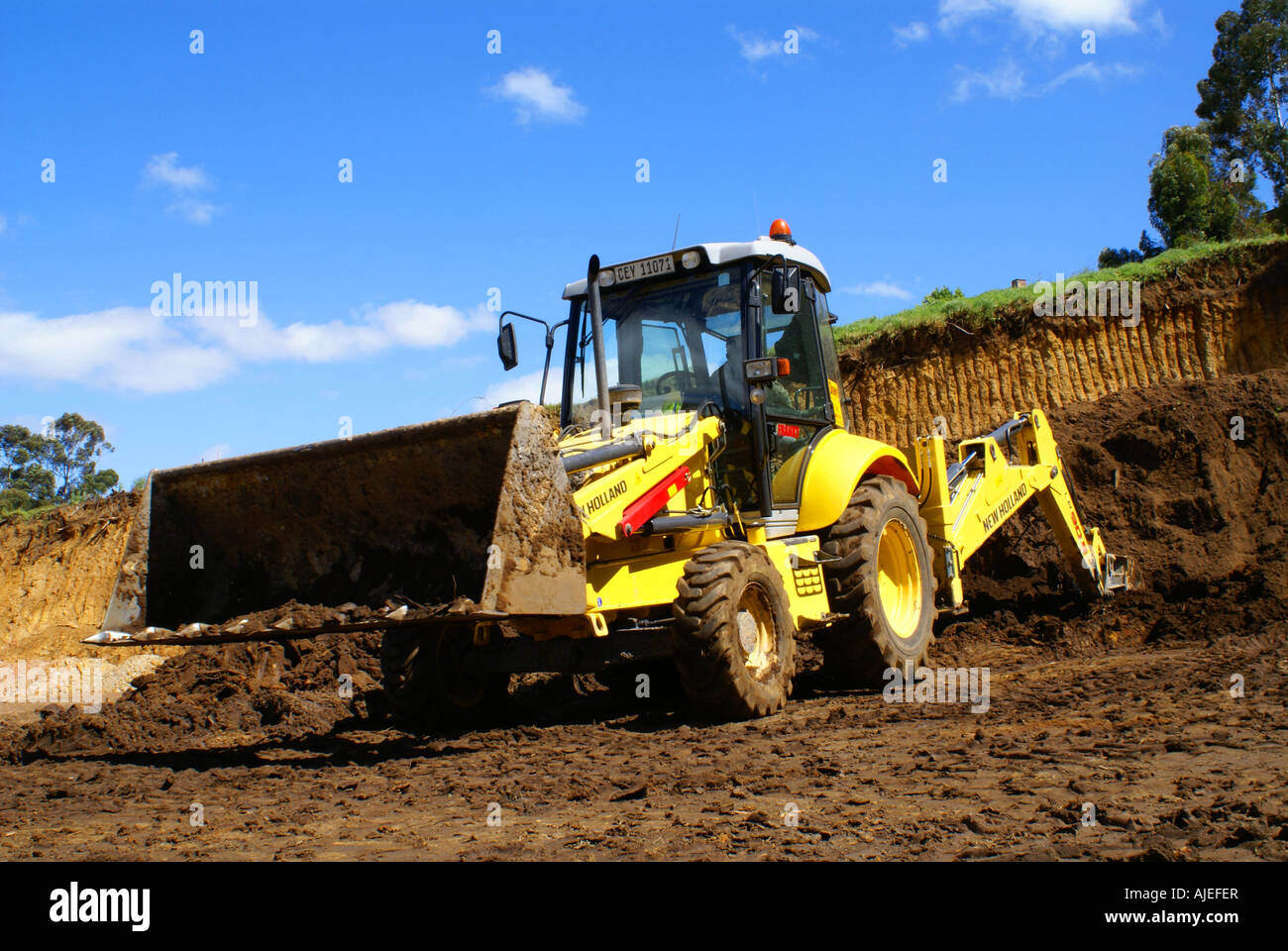 Yellow front loader and back hoe Stock Photo - Alamy