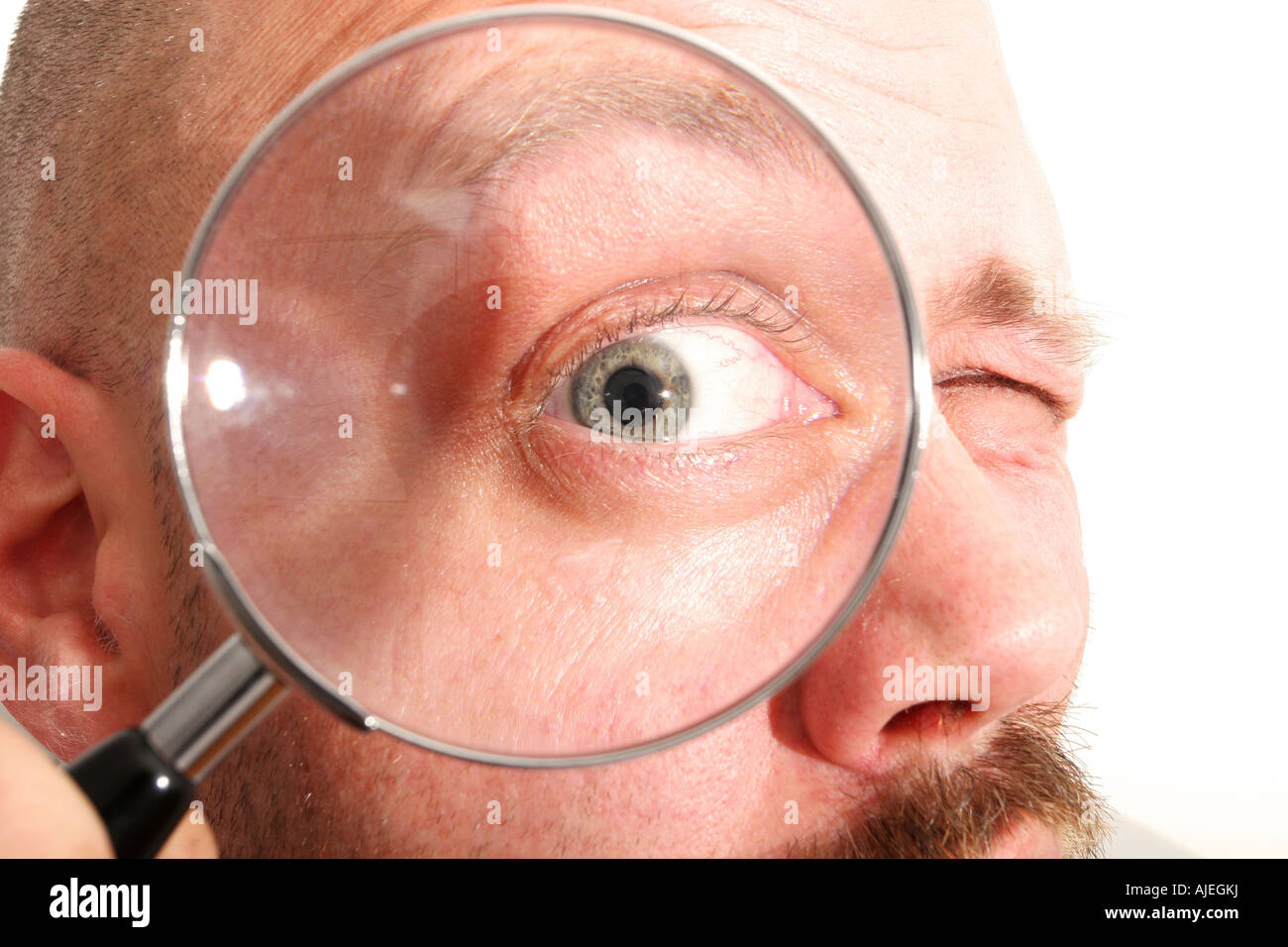 A man looking through a magnifying glass weird view Stock Photo - Alamy
