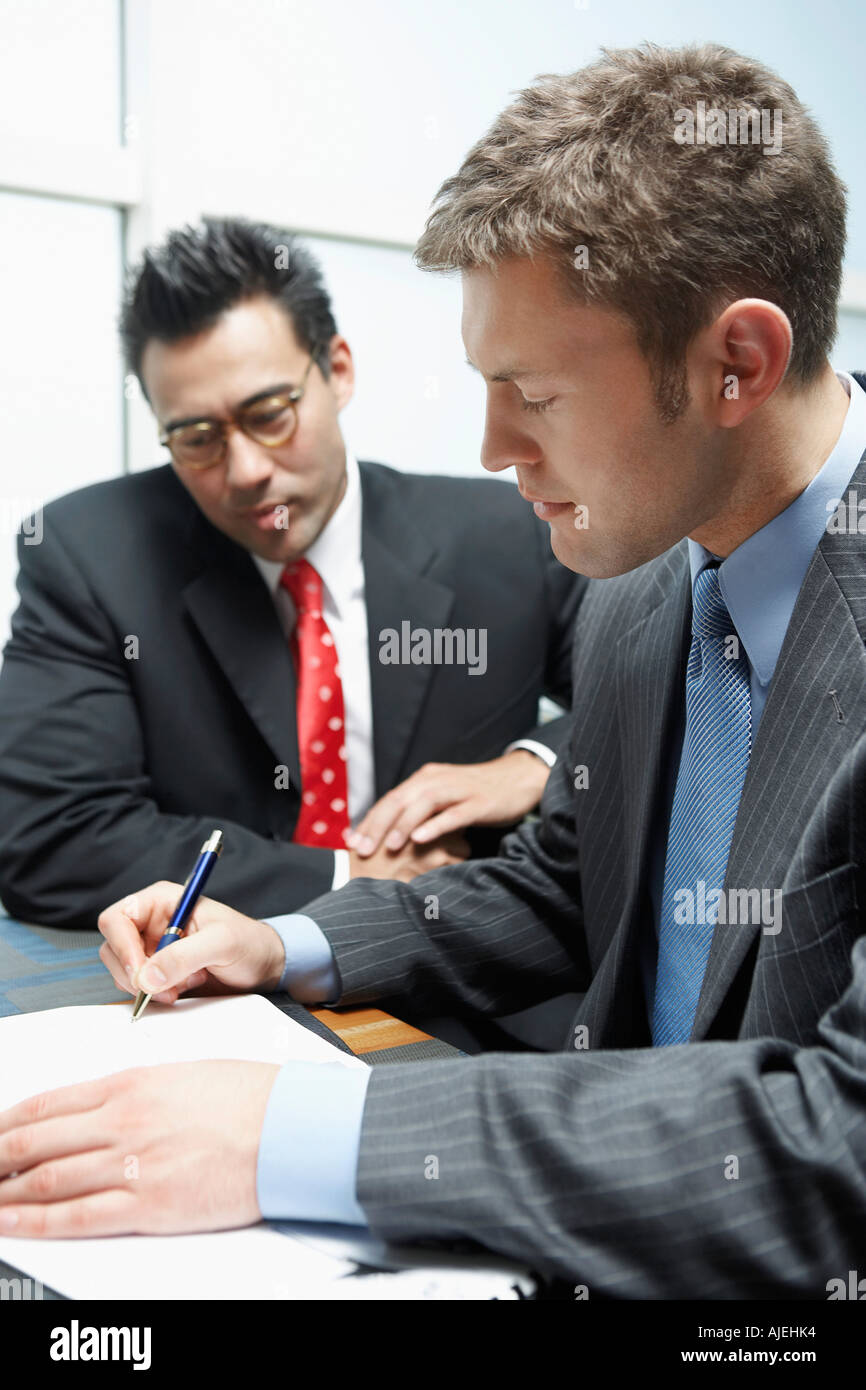 Two Businessmen in Meeting, signing contract Stock Photo - Alamy