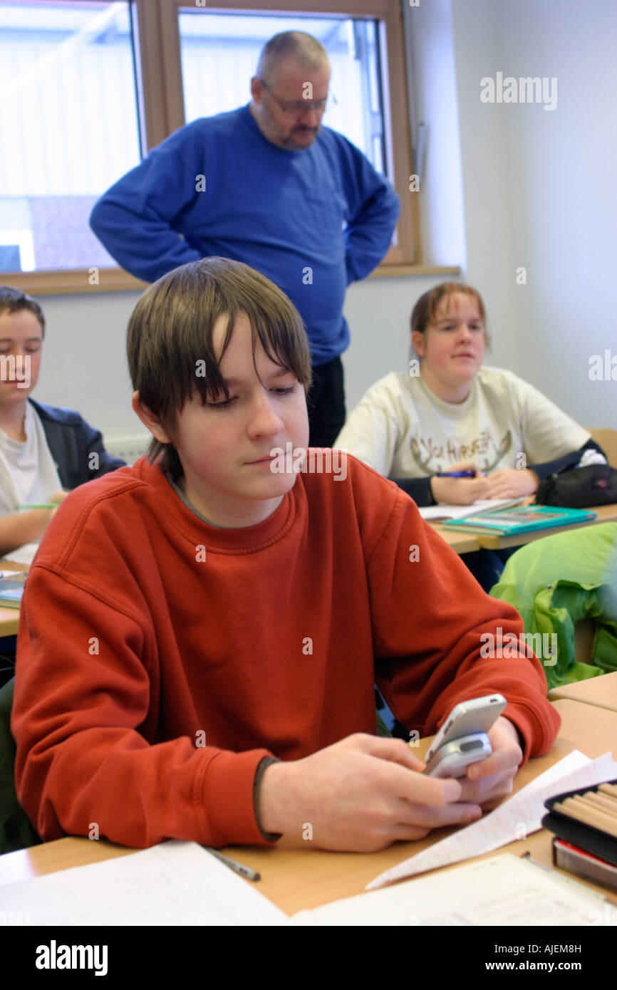 teenager playing with a mobile phone during class Stock Photo - Alamy