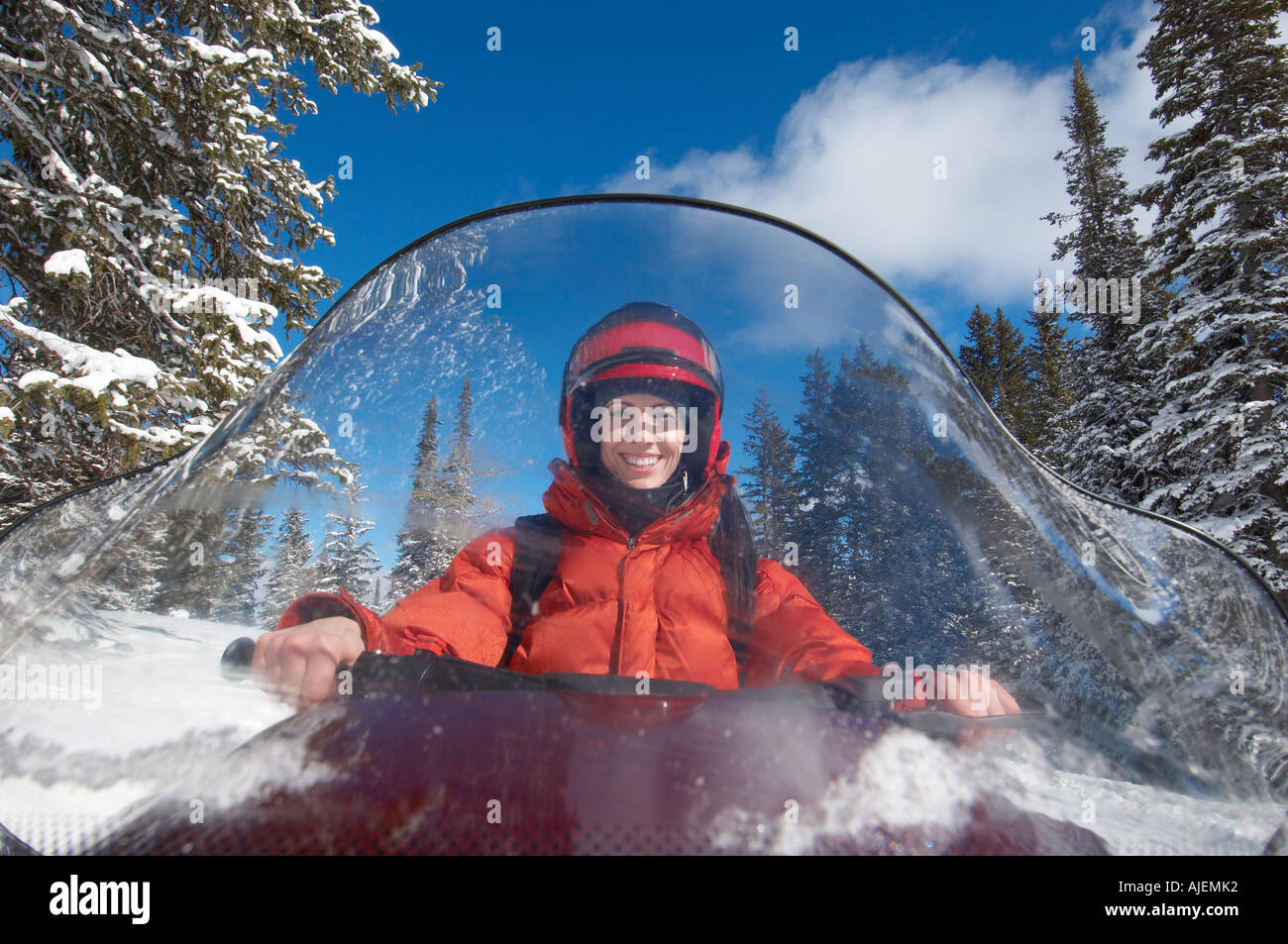 Woman driving snowmobile through snow, front view Stock Photo - Alamy