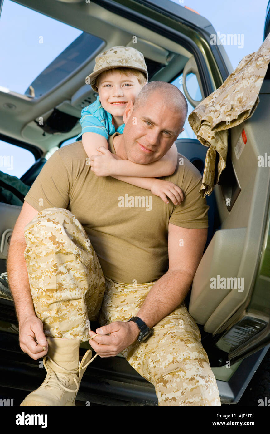 Boy (5-6) embracing military father in vehicle, (portrait Stock Photo ...