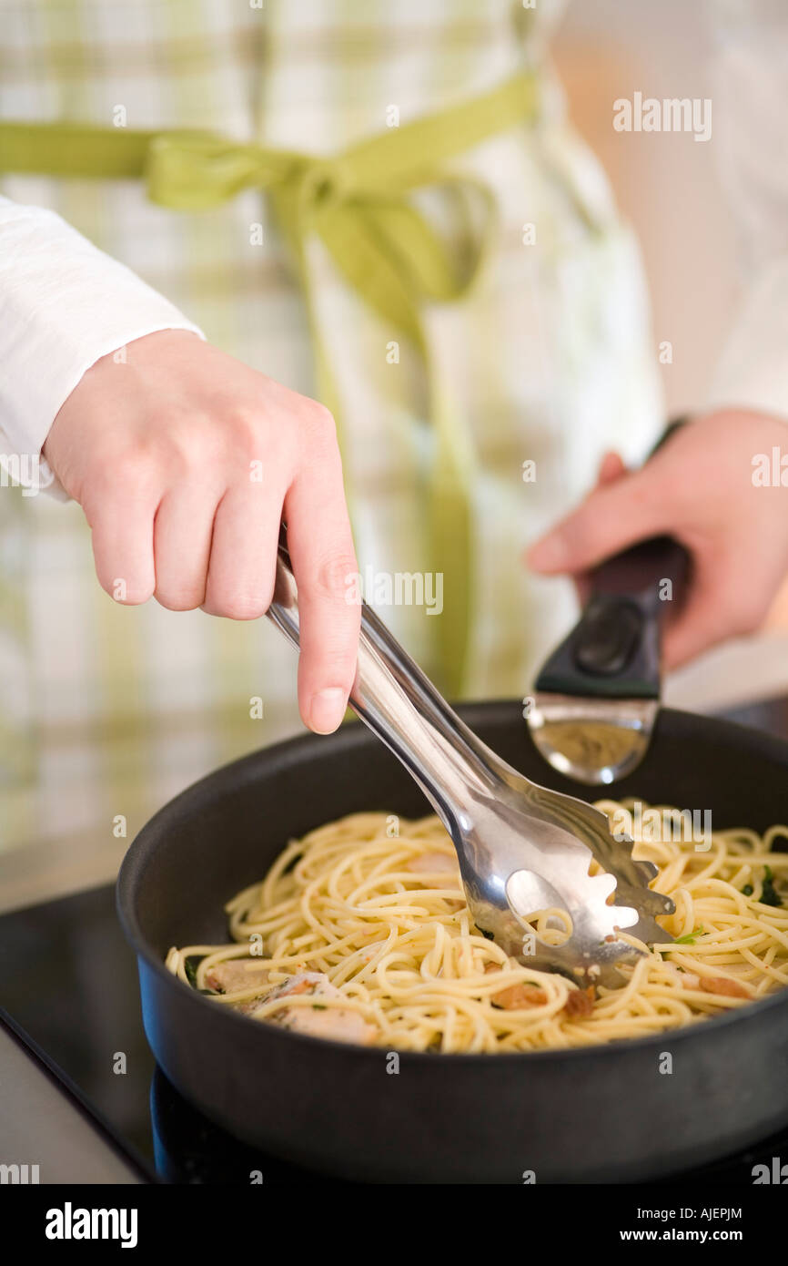 Young woman cooking spaghetti Stock Photo - Alamy