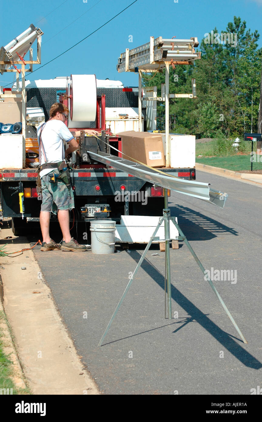 Installation of rain water run off gutters by young men on ladders and ...