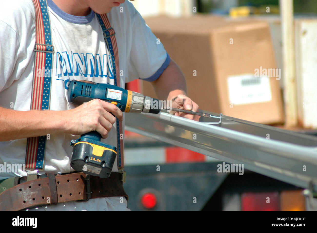 Installation of rain water run off gutters by young men on ladders and ...
