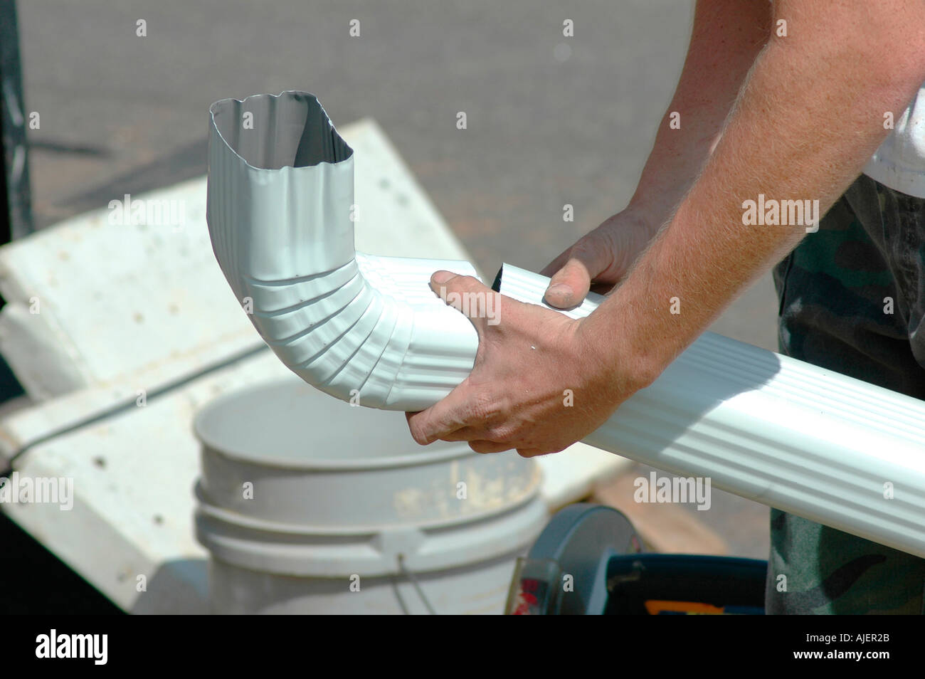Installation of rain water run off gutters by young men on ladders and ...