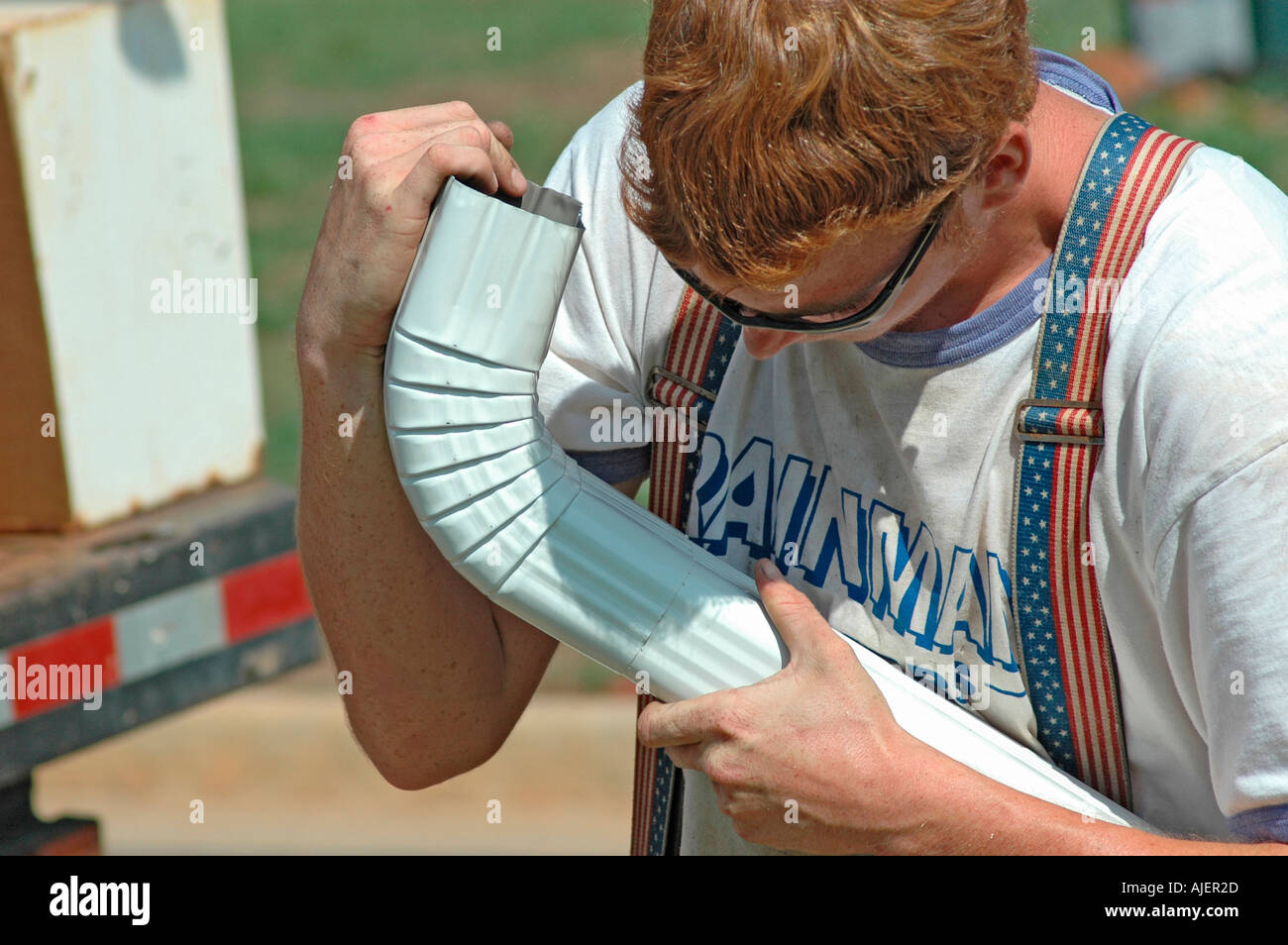 Installation of rain water run off gutters by young men on ladders and ...