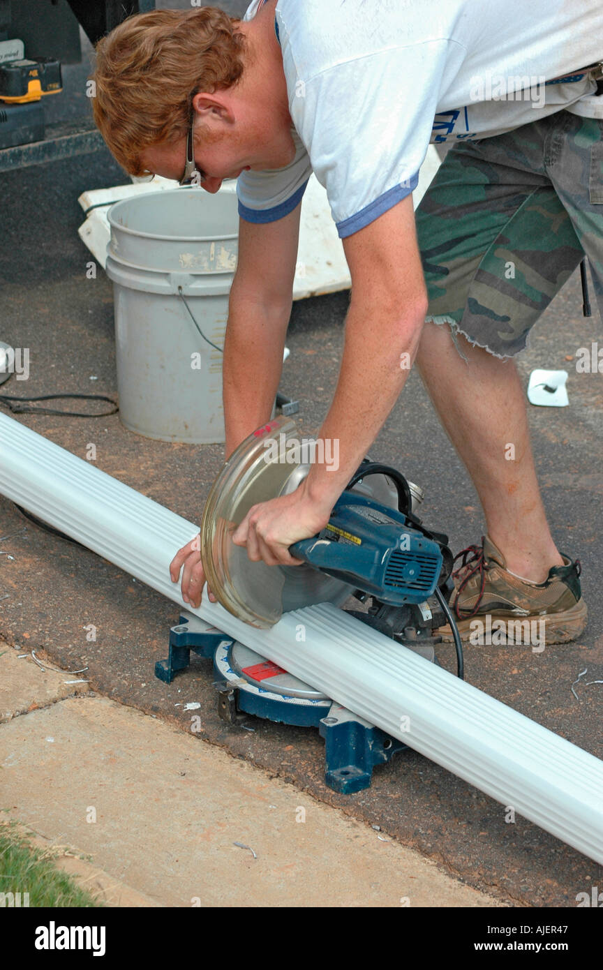 Installation of rain water run off gutters by young men on ladders and ...
