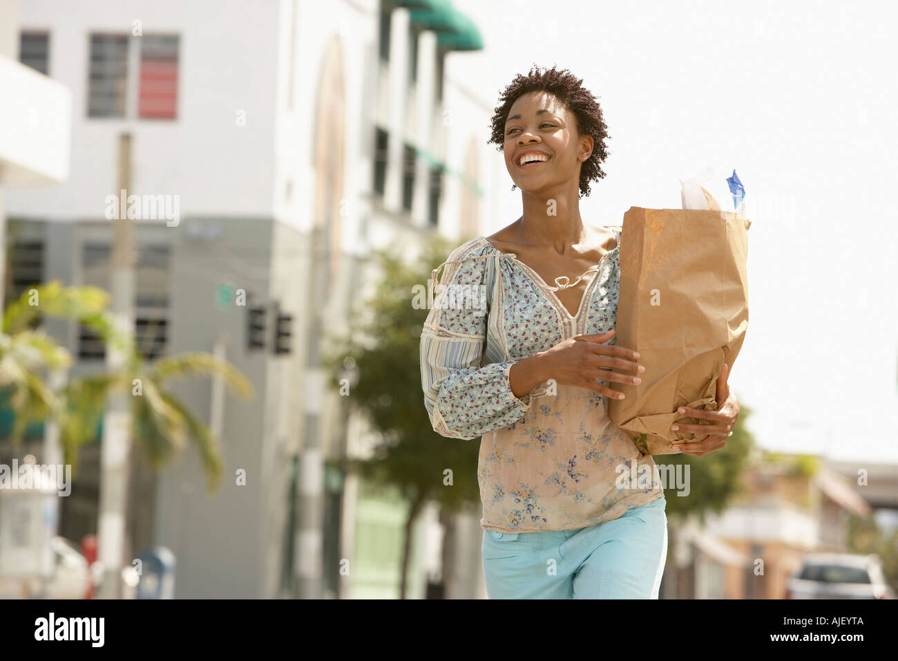 Smiling young woman carrying groceries, portrait Stock Photo - Alamy