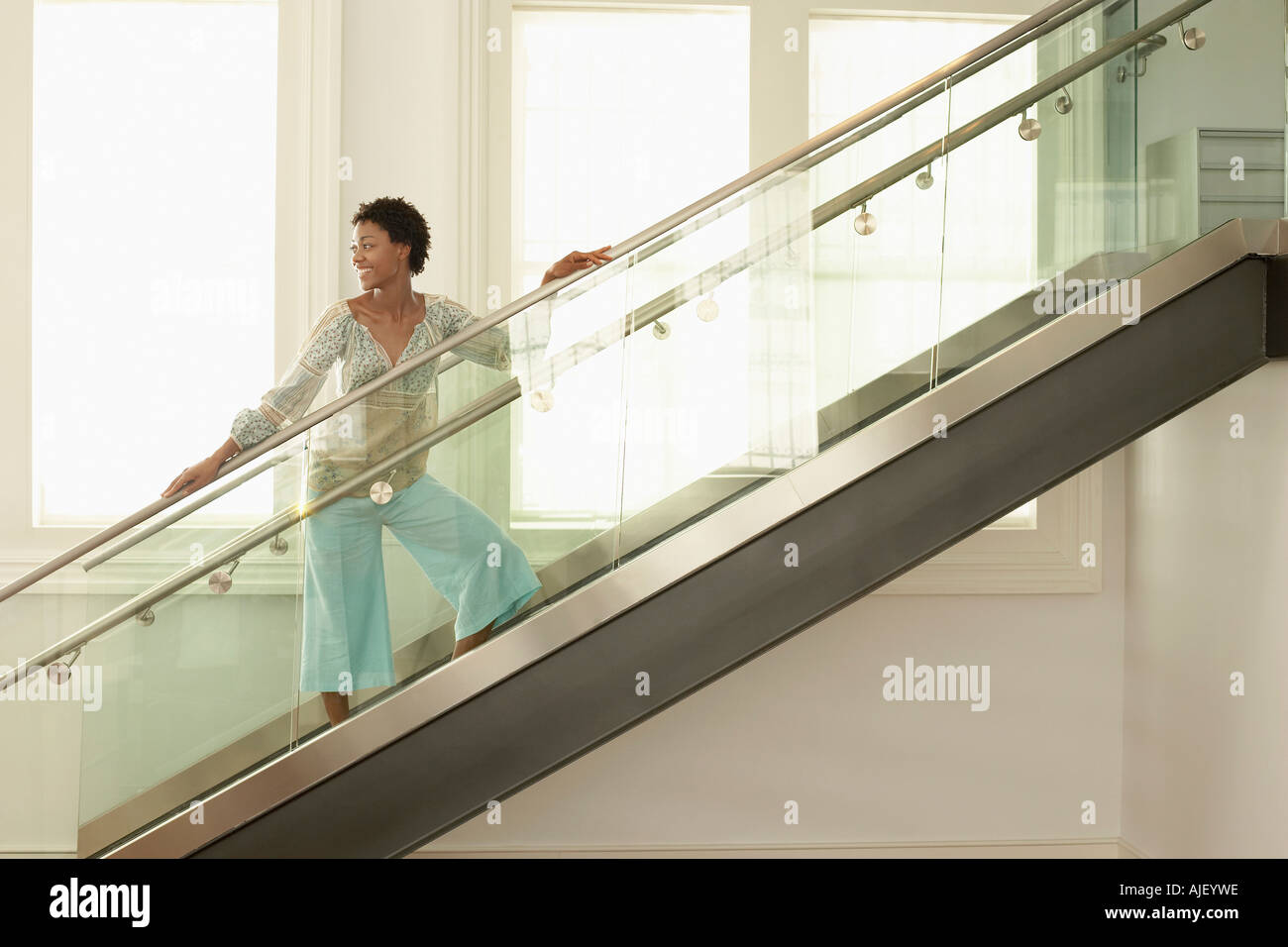 Young woman standing on modern glass stairs, portrait Stock Photo - Alamy