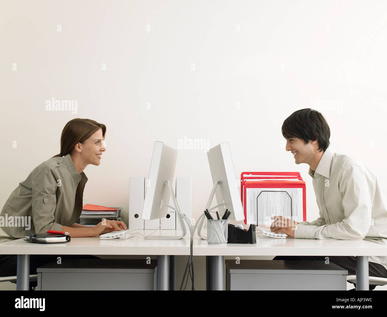 Business Man and Woman Working on Computers, Face to Face Stock Photo ...