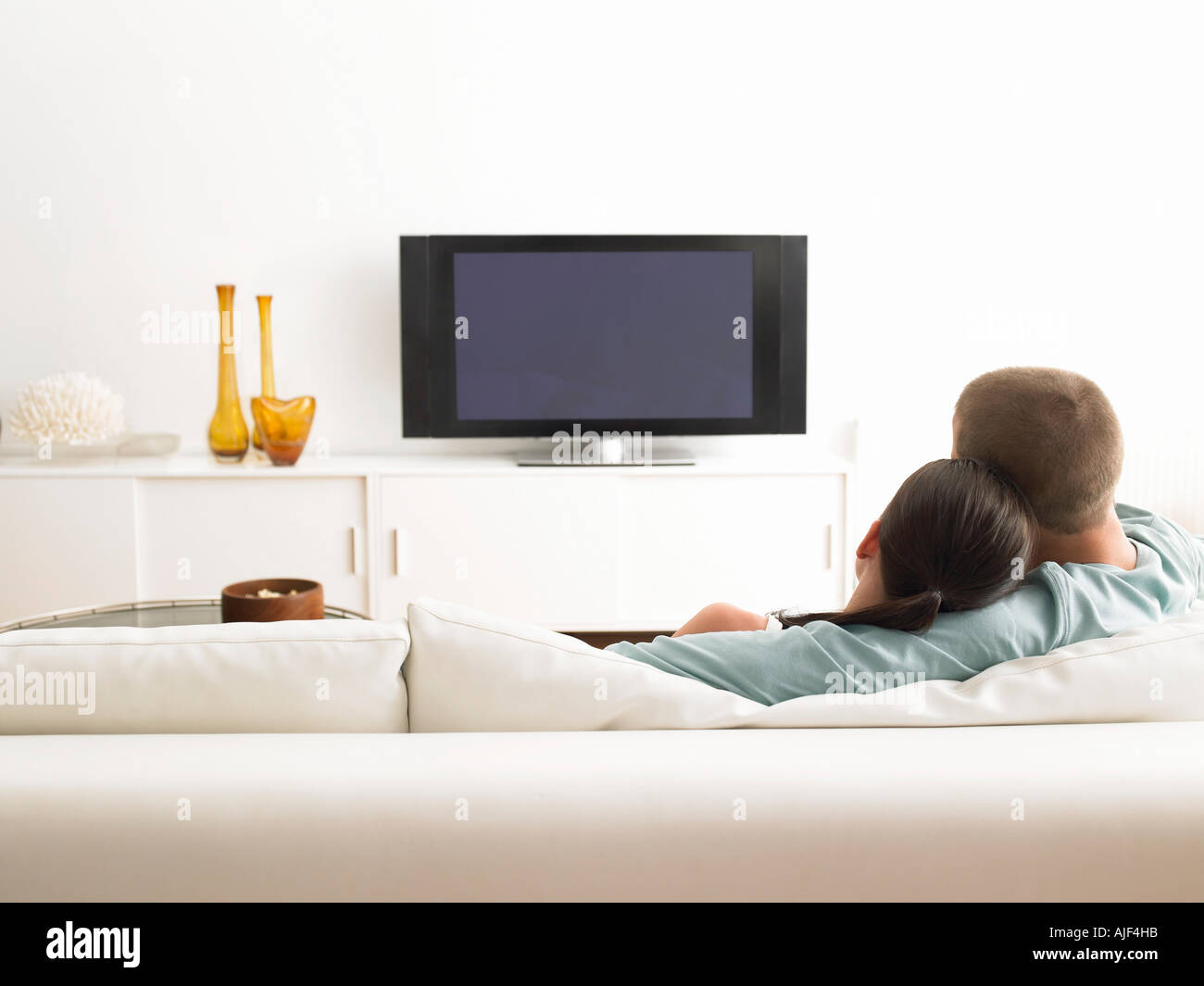 Rear View of couple on sofa watching TV Stock Photo - Alamy