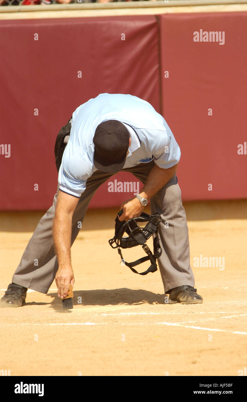 Home plate umpire brushes the dirt off the plate Stock Photo - Alamy