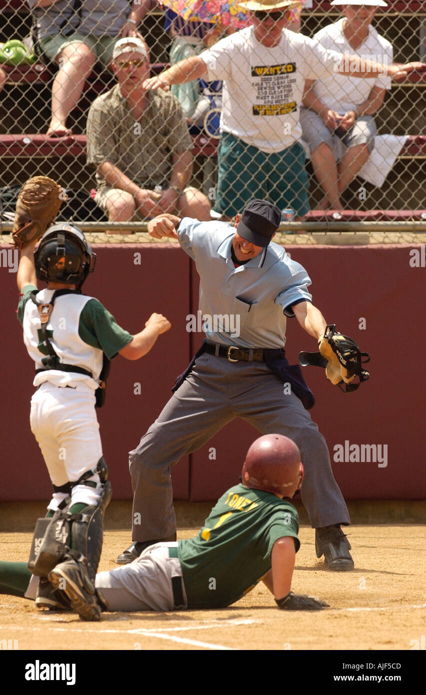 Youth baseball game action Home plate umpire calls the runner out while ...