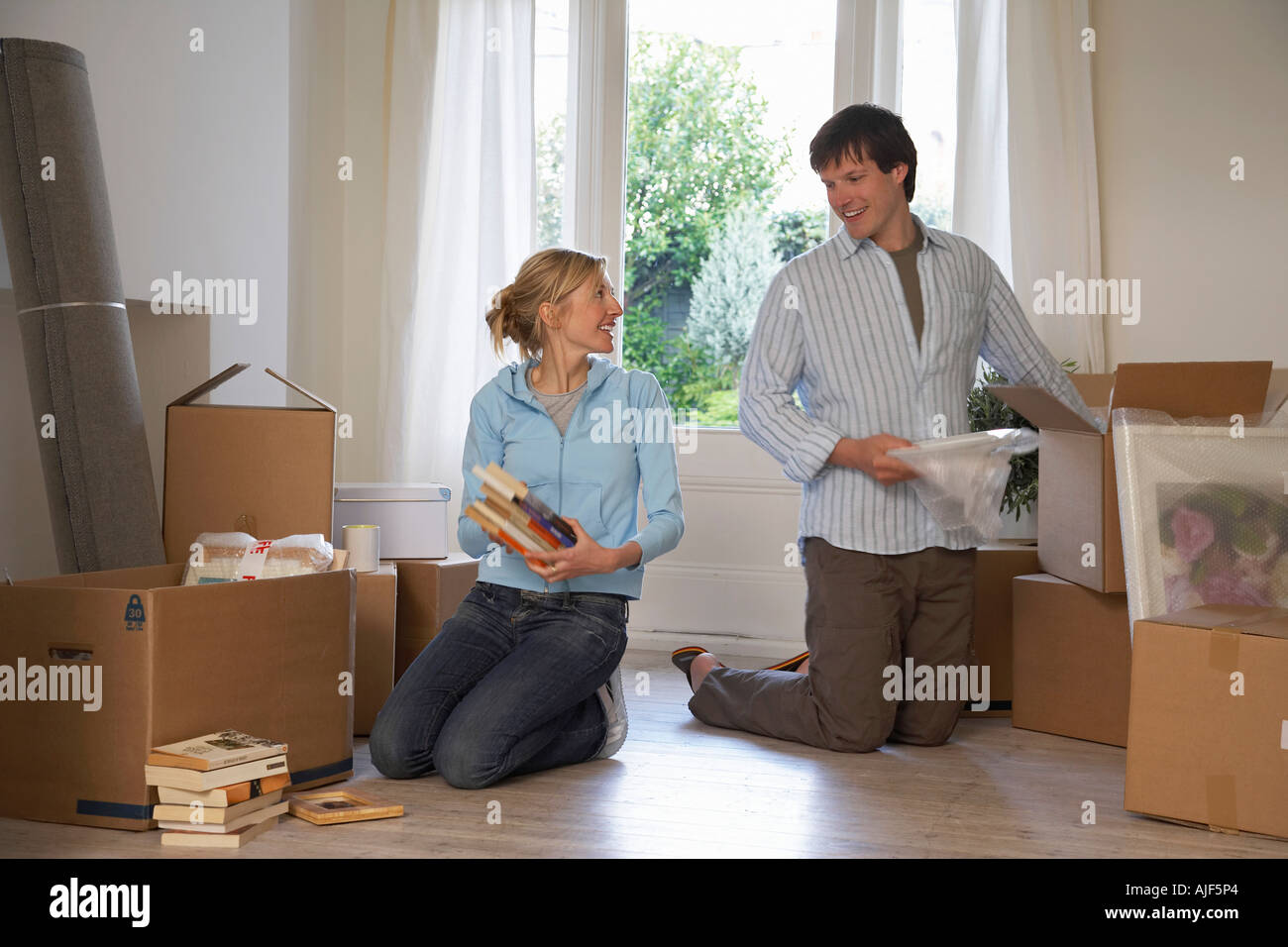 Man kneeling unpacking cardboard hi-res stock photography and images ...