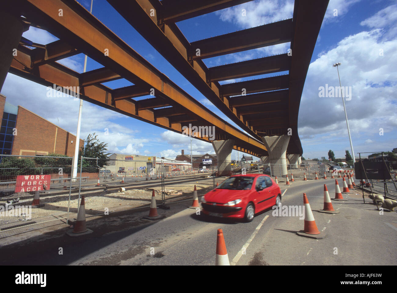 car traveling underneath construction work of new flyover road bridge ...