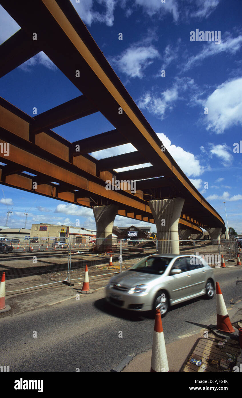 car travelling underneath construction of flyover road bridge crossing ...