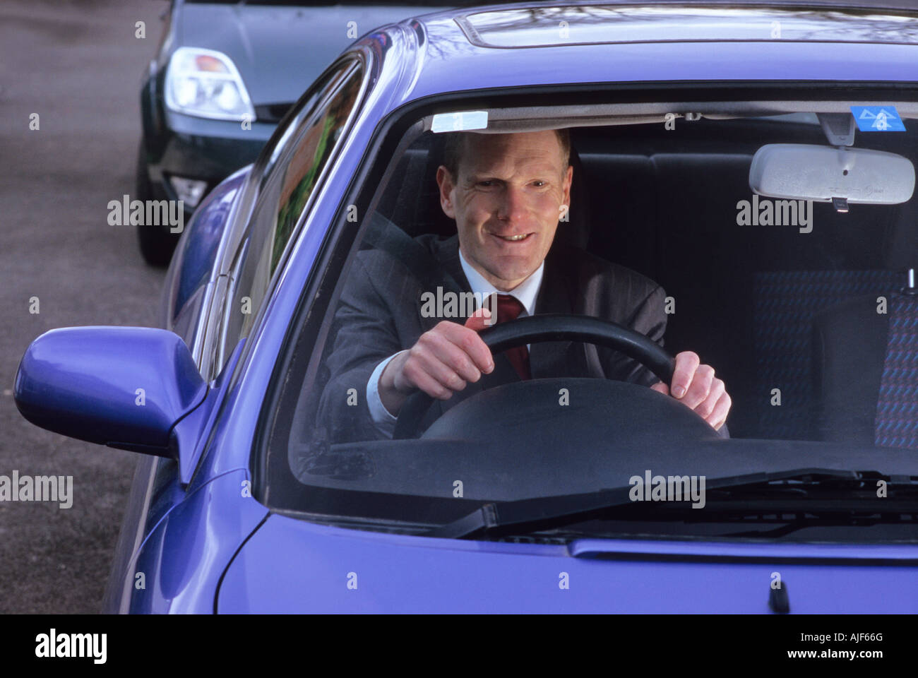 happy businessman driving car down road uk Stock Photo - Alamy
