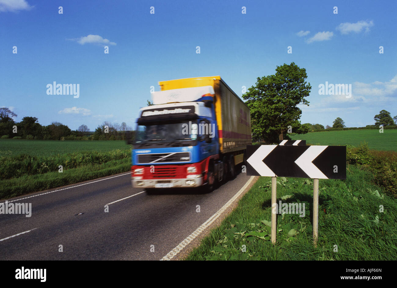 lorry passing black and white chevron warning sign of sharp bend in ...