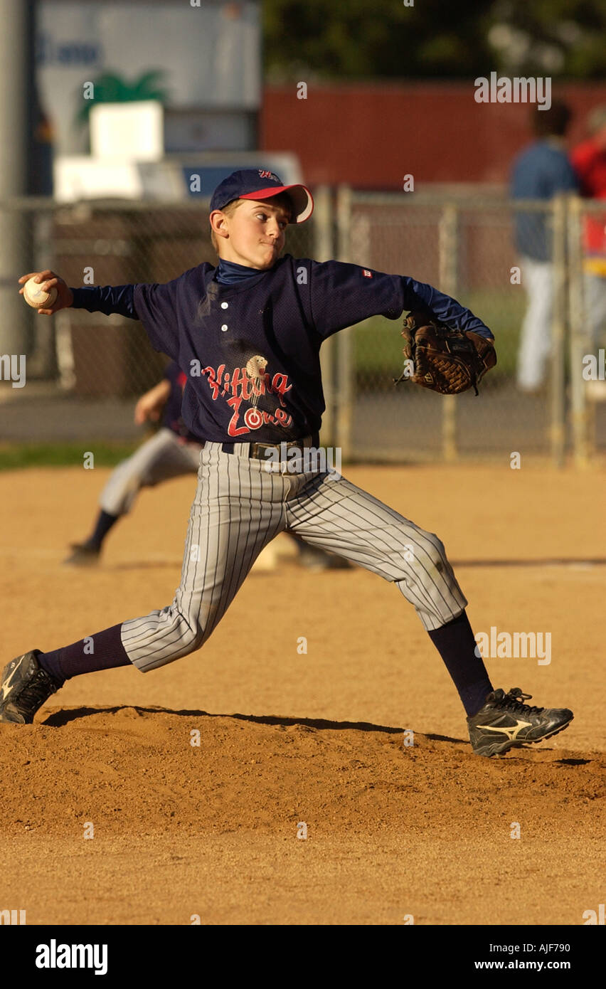 Youth baseball pitcher winds up and throws the ball Stock Photo - Alamy