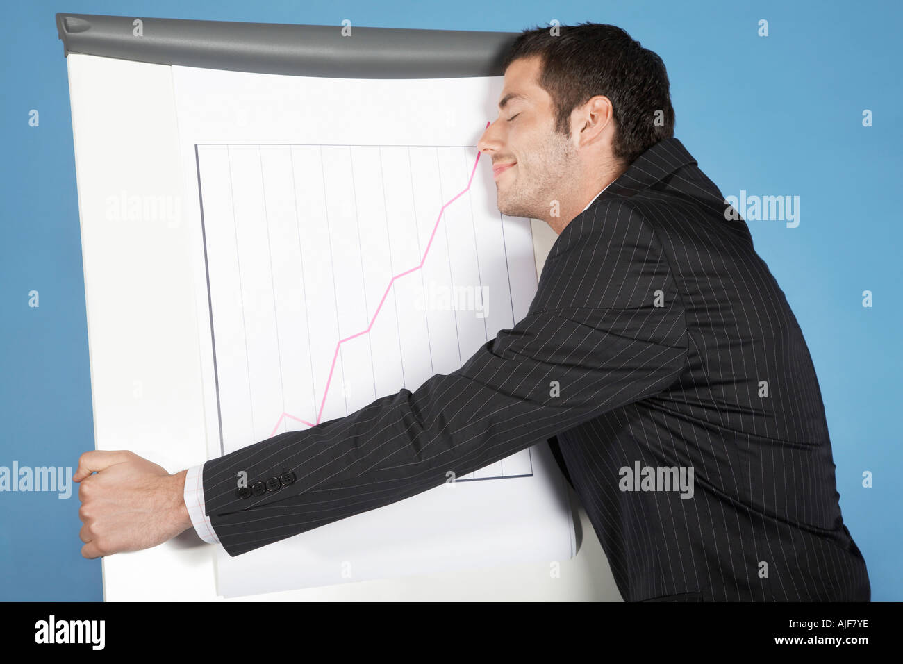 Businessman hugging line graph showing success Stock Photo - Alamy