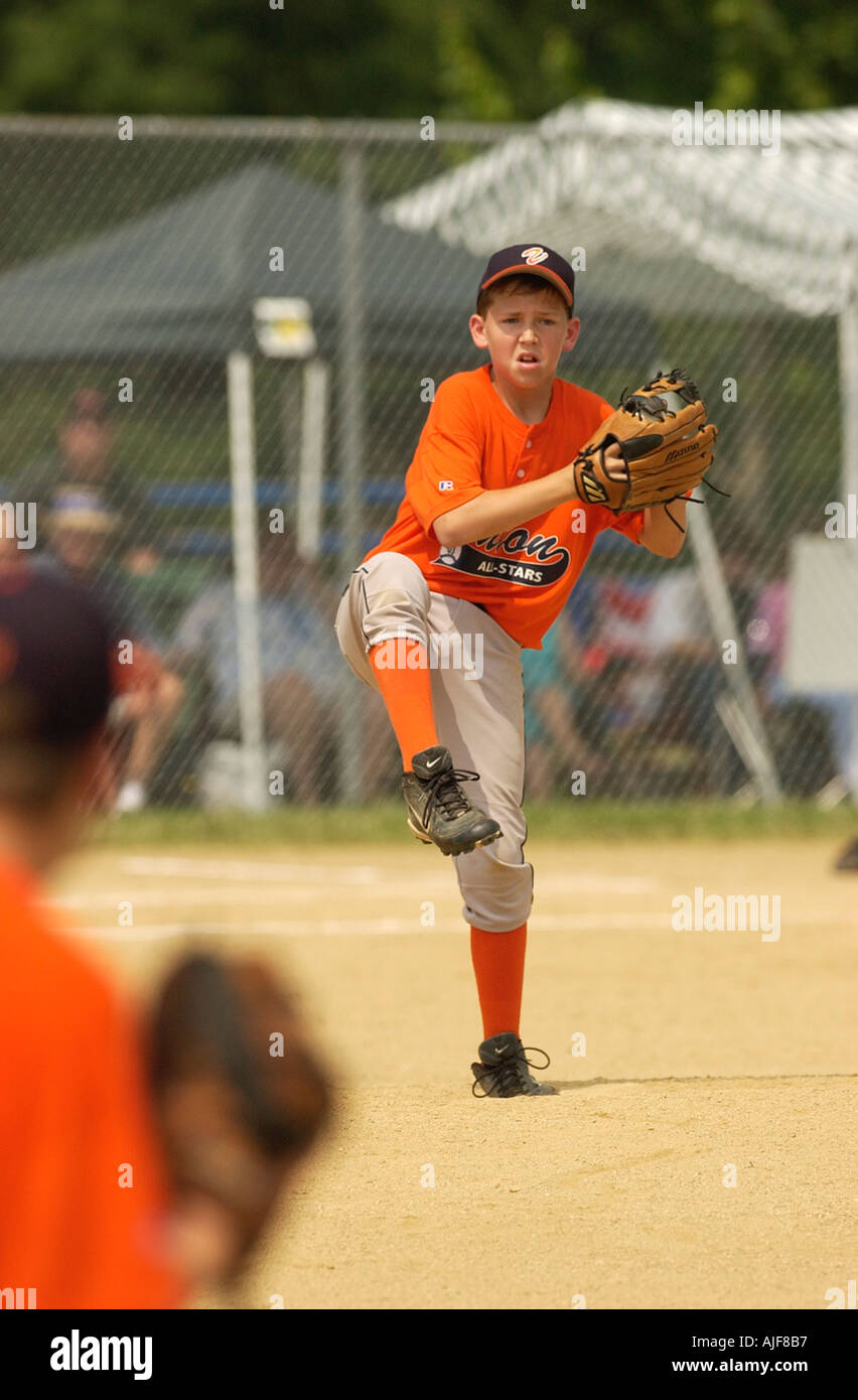 Youth baseball pitcher looks to first to hold the runner Stock Photo ...