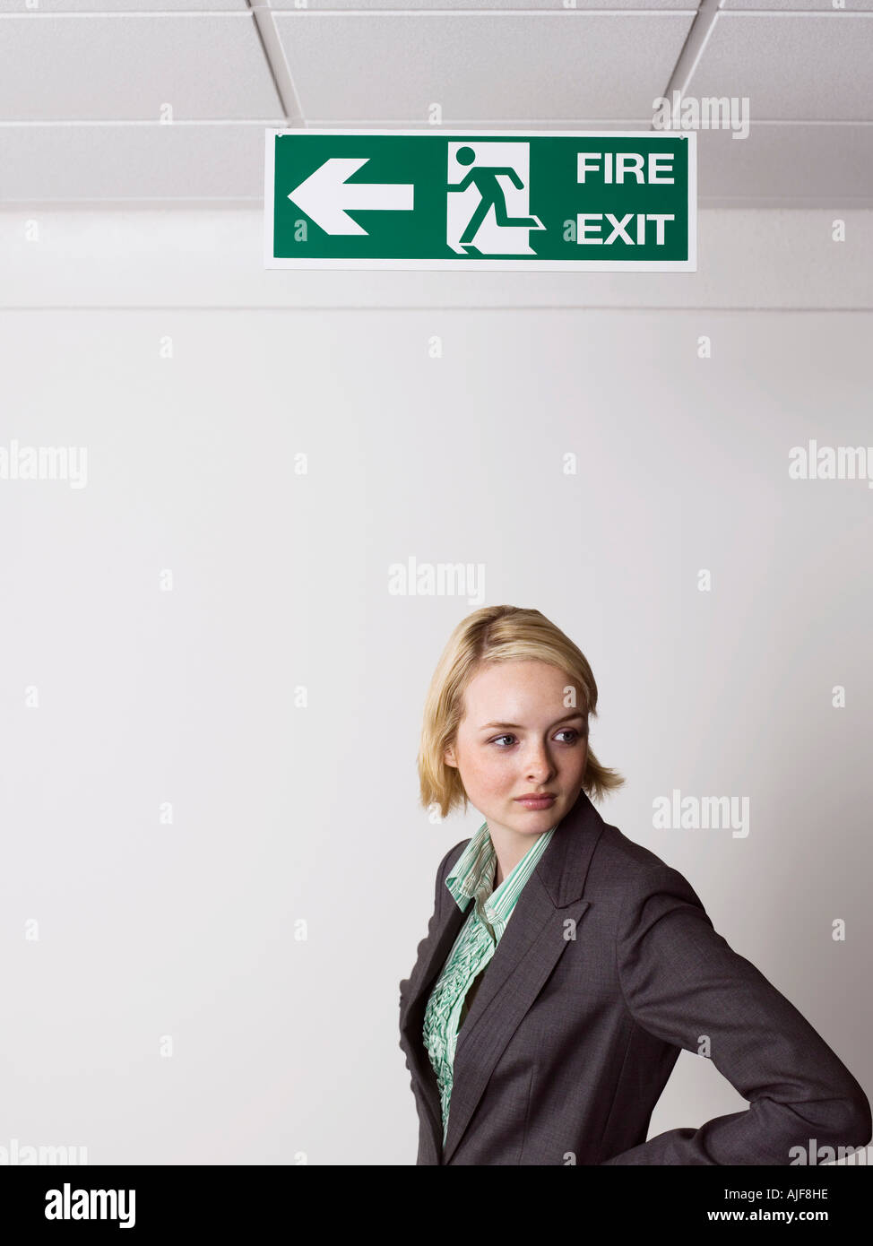 Businesswoman standing under exit sign Stock Photo - Alamy
