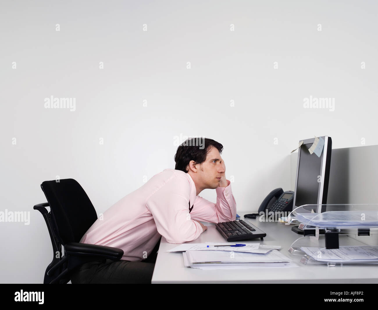 Bored office worker at desk in office Stock Photo - Alamy