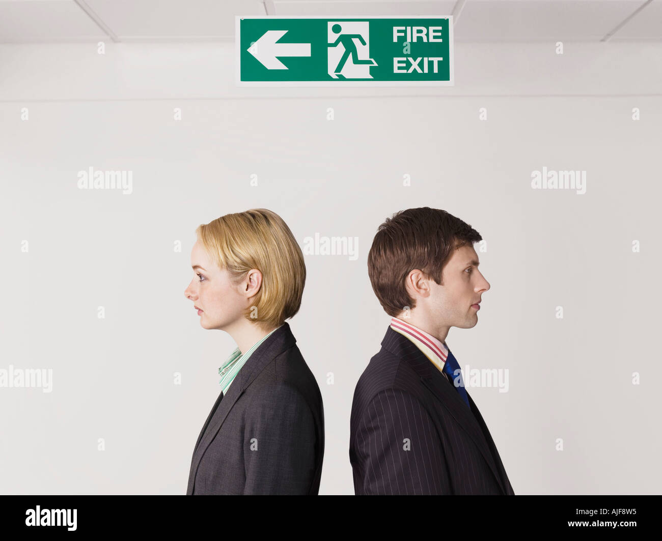Business colleagues standing under exit sign Stock Photo - Alamy
